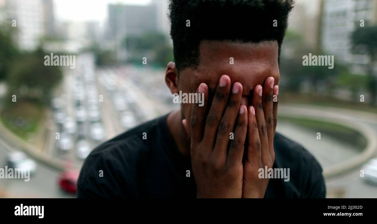 Anxious young black African man suffering in city Stock Photo - Alamy