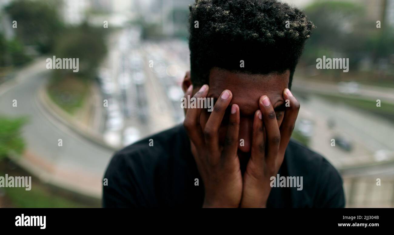 Anxious young black African man suffering in city Stock Photo - Alamy