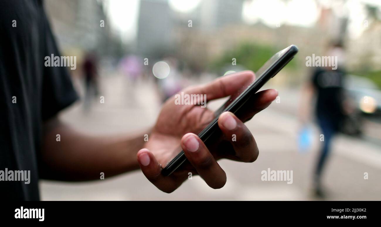 Close-up black man hand holding cellphone device in street Stock Photo ...