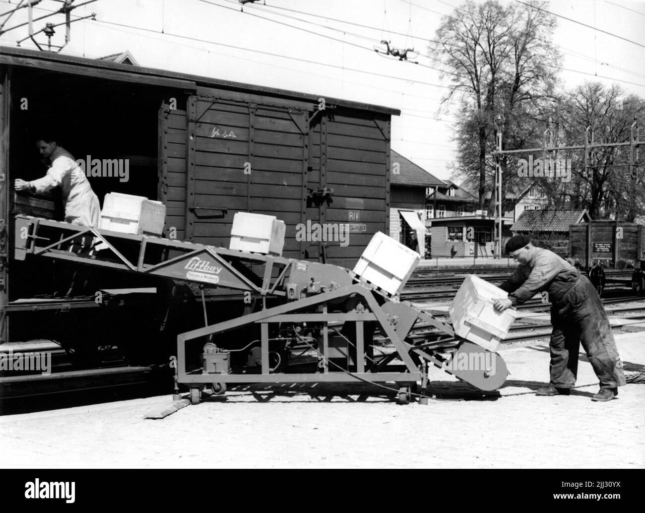Loading boxes on the train, two men.vretstorp Stock Photo - Alamy