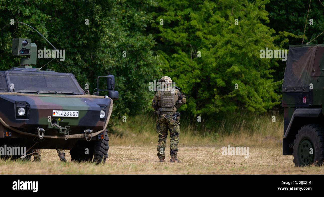 13 July 2022, Lower Saxony, Lüneburg: A Bundeswehr soldier stands next ...