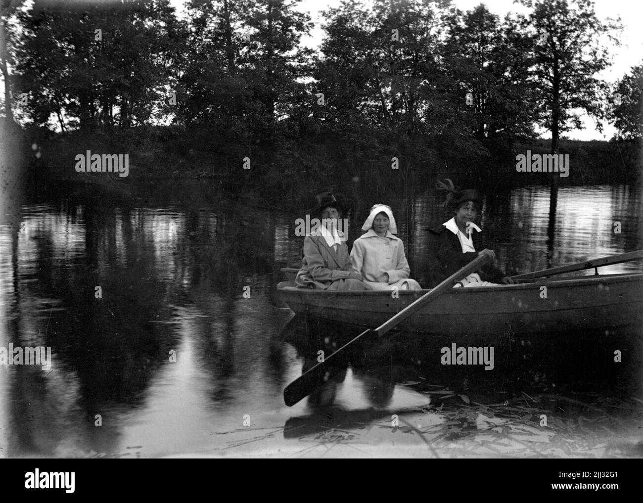 Örebro colony. Three women in a rowing boat Stock Photo - Alamy