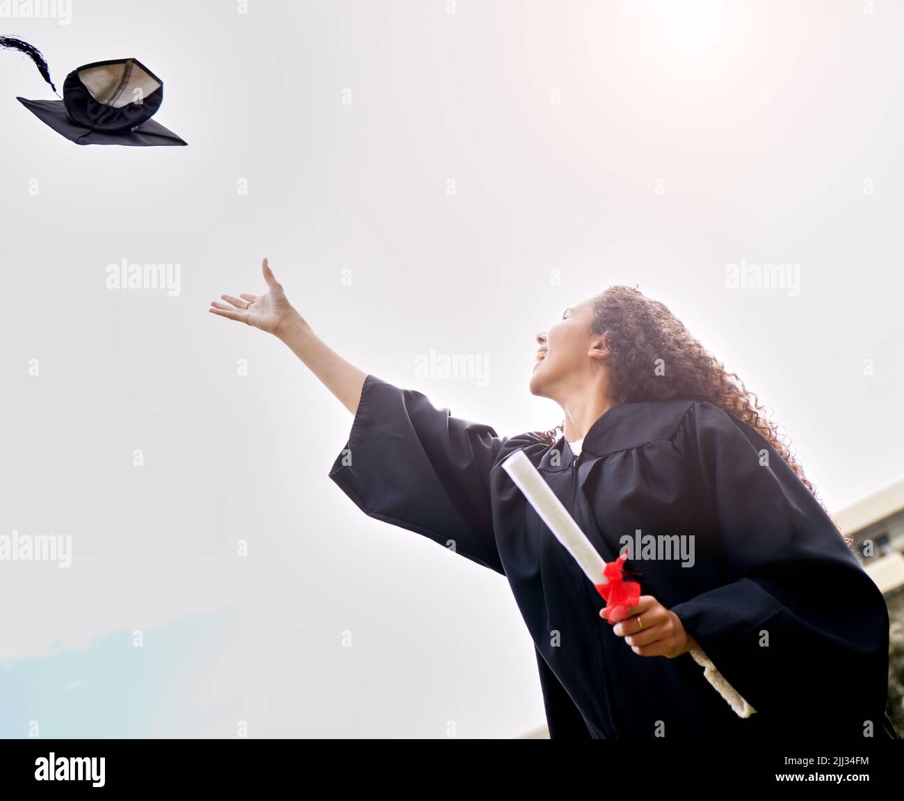 Shell go far in life. Low angle shot of a young woman tossing her hat ...