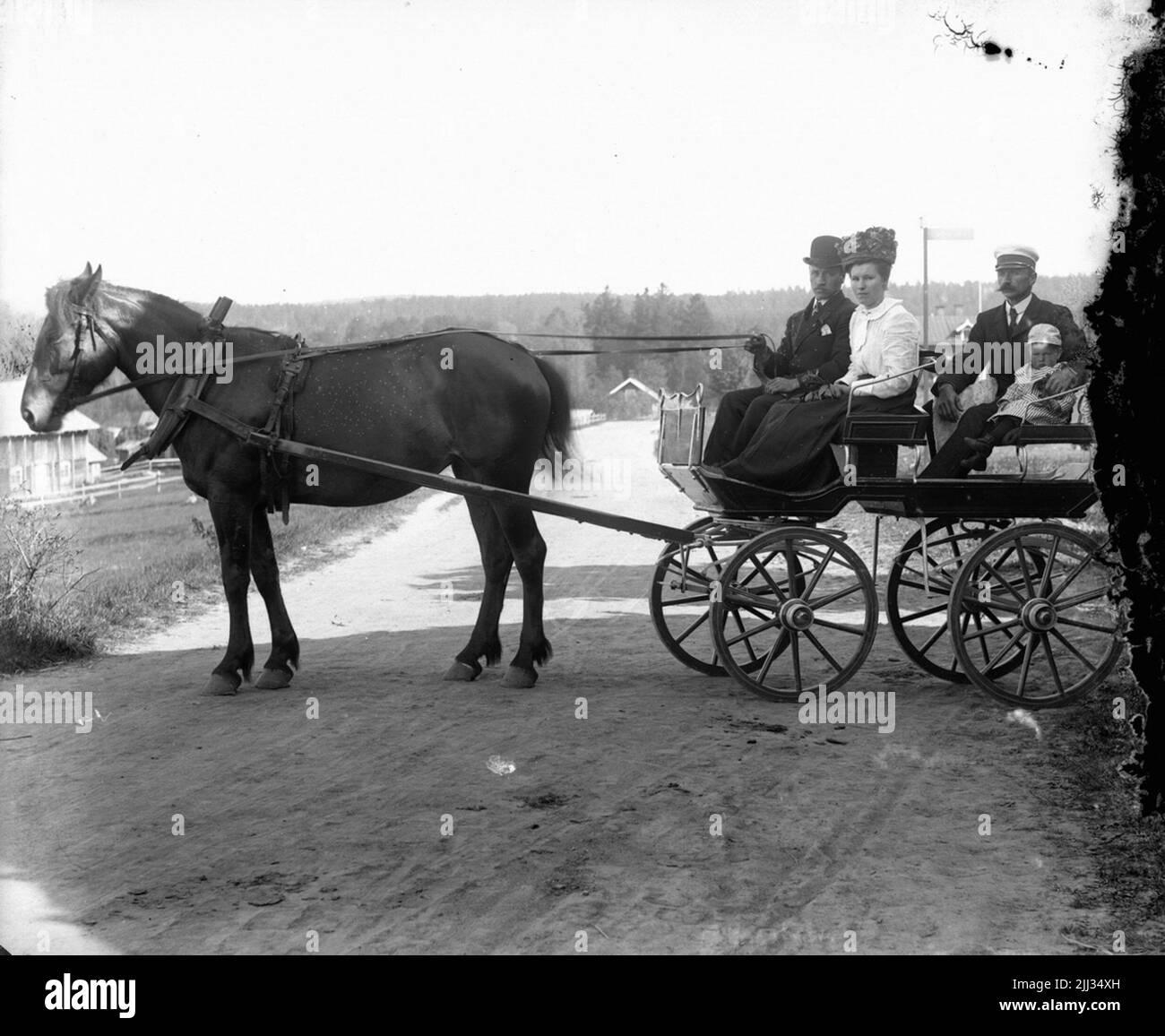 Horse with carriage, four people in the carriage Stock Photo - Alamy
