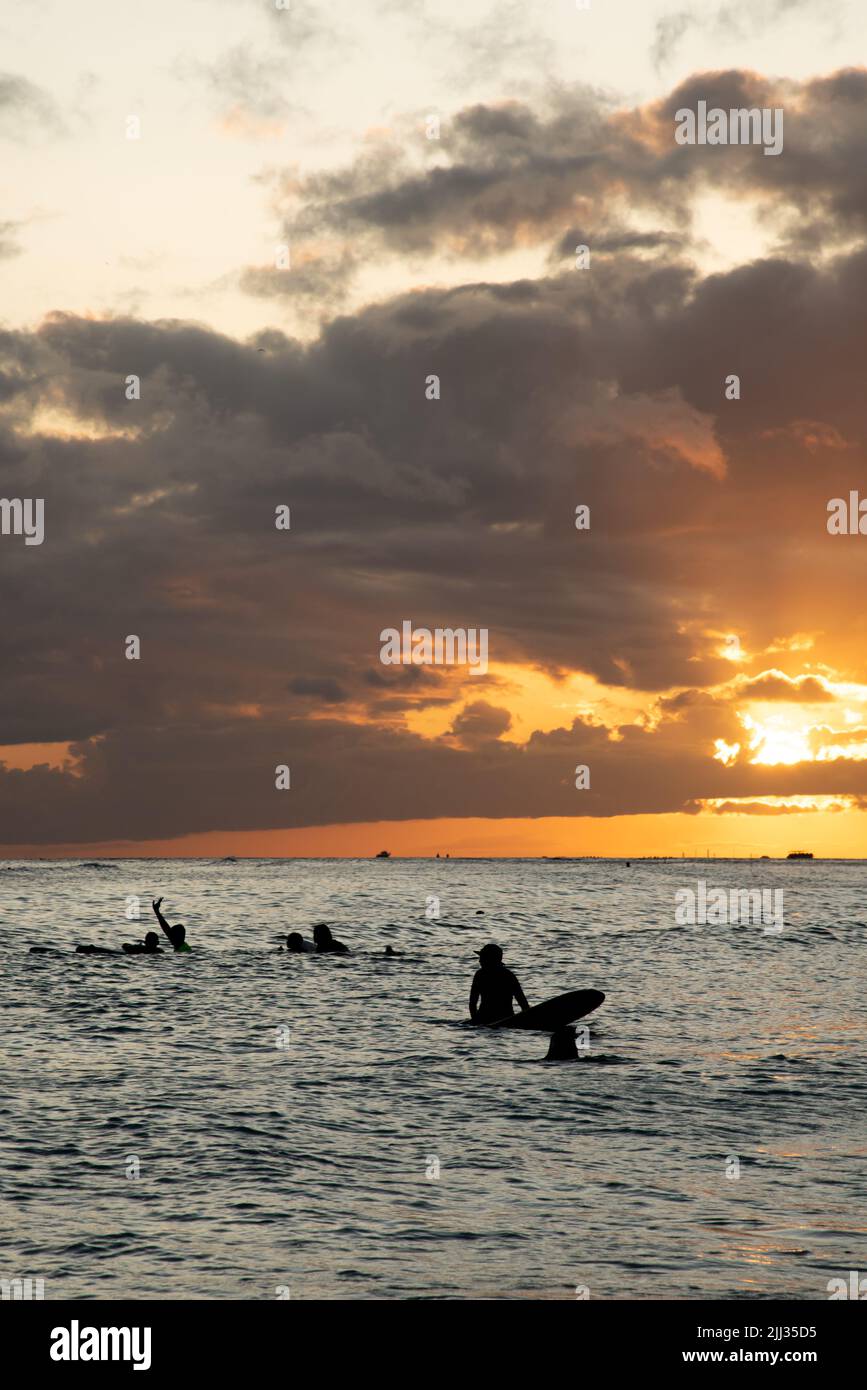 Sunset with stunning full sun setting over the pacific ocean. Surfer ...