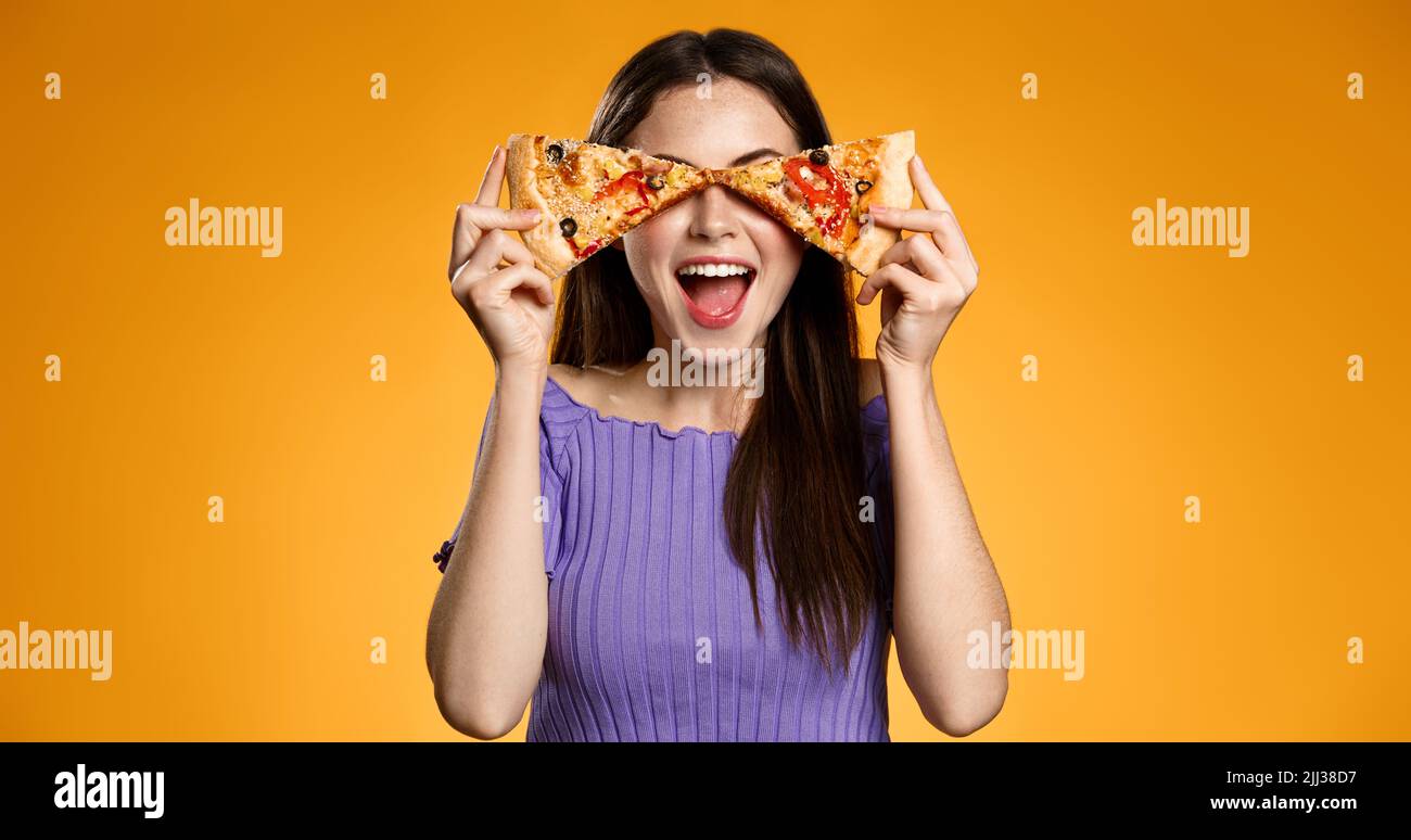 Happy smiling woman holding pizza slices on eyes with excited face ...