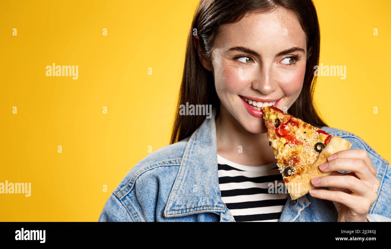 Image of girl smiling while biting slice of pizza, happy face at ...