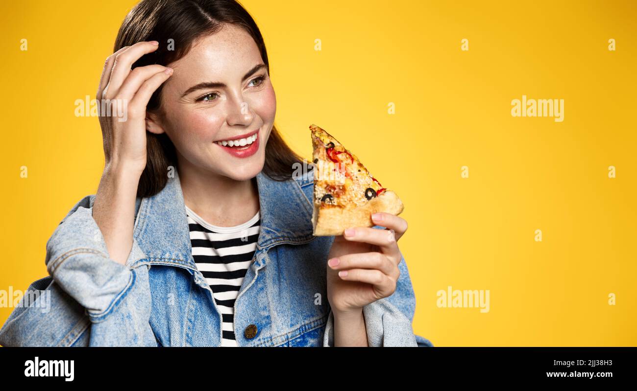 Image of girl smiling while biting slice of pizza, happy face at ...