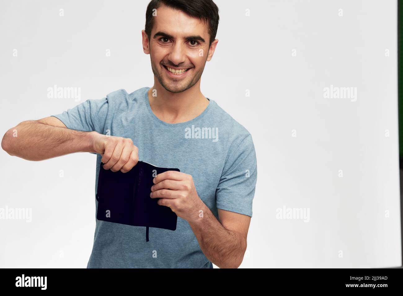 handsome man with a notepad in hand casual wear posing emotions light ...