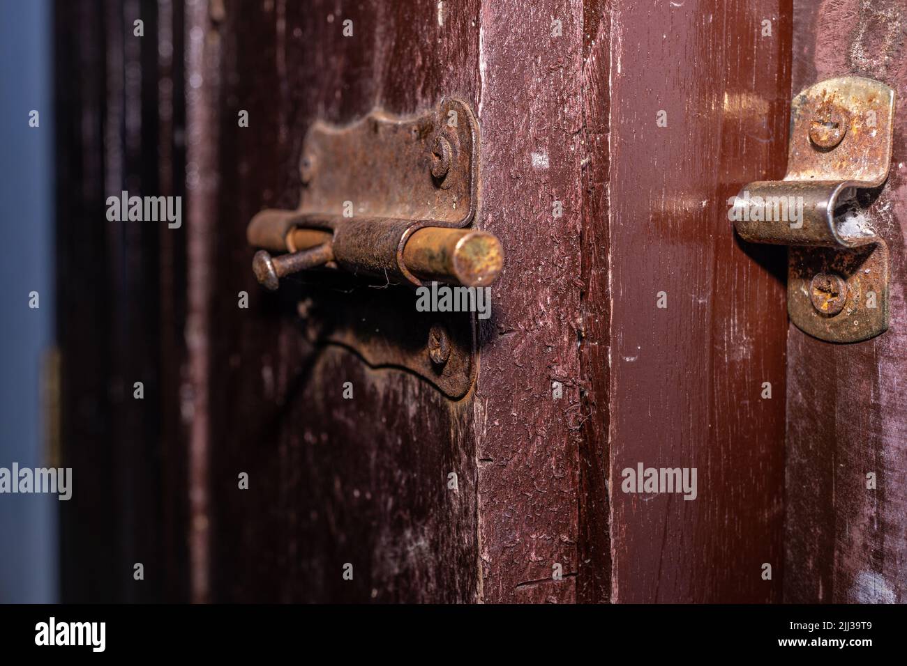 Corroded door bolt and latch on wooden door Stock Photo - Alamy