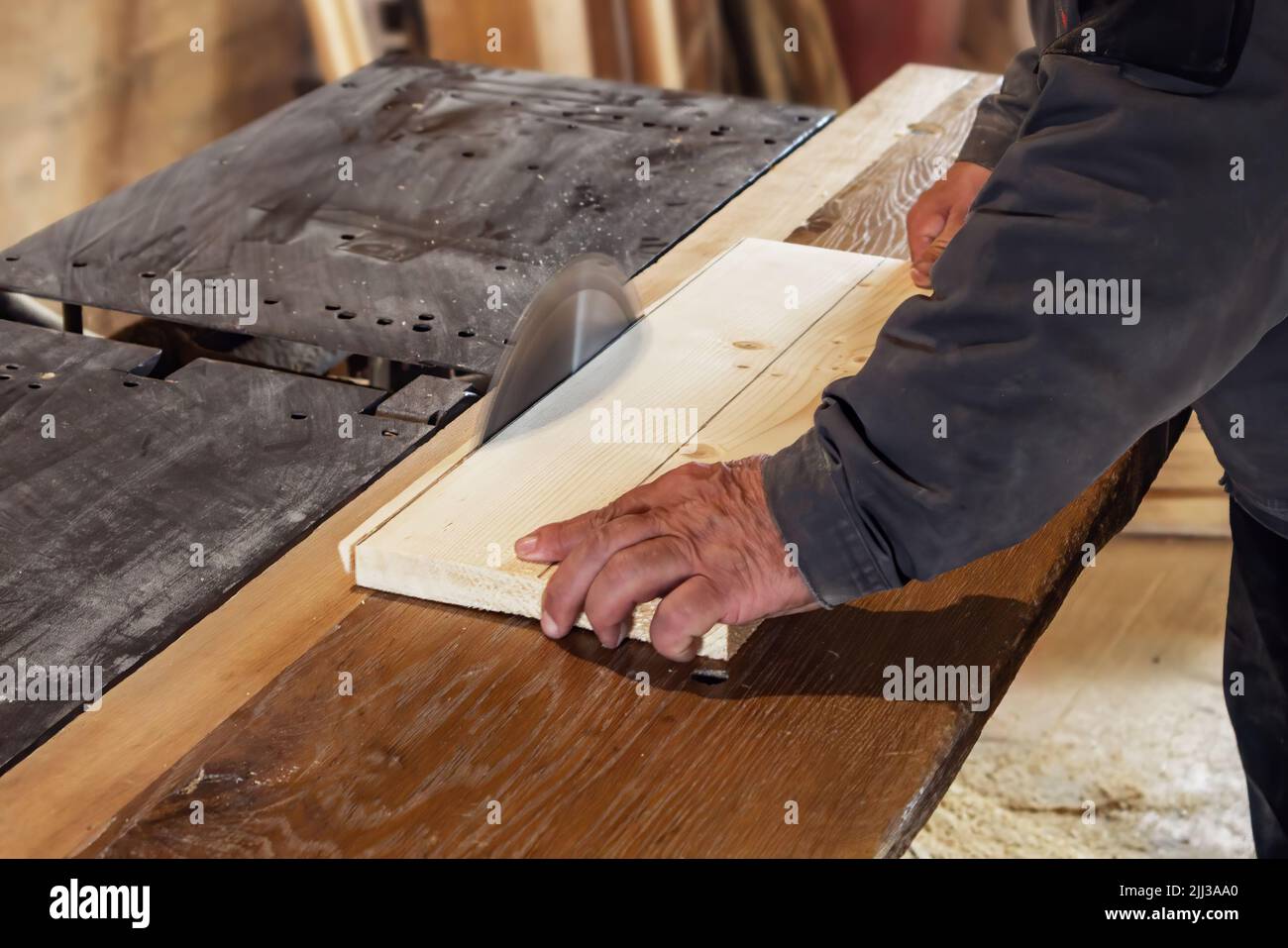 carpenter saws a wooden board with a carpentry machine. old rustic ...