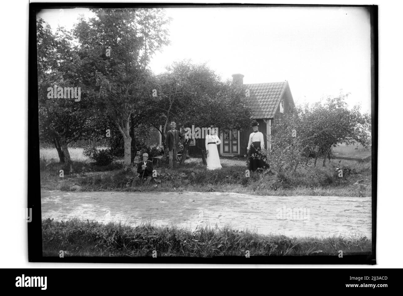 Simple cottage and four people. Wife Englin Stock Photo - Alamy