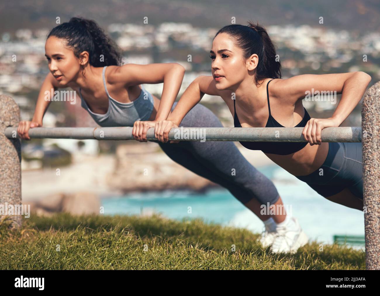 No rest for the wicked. two young friends doing push ups together Stock ...