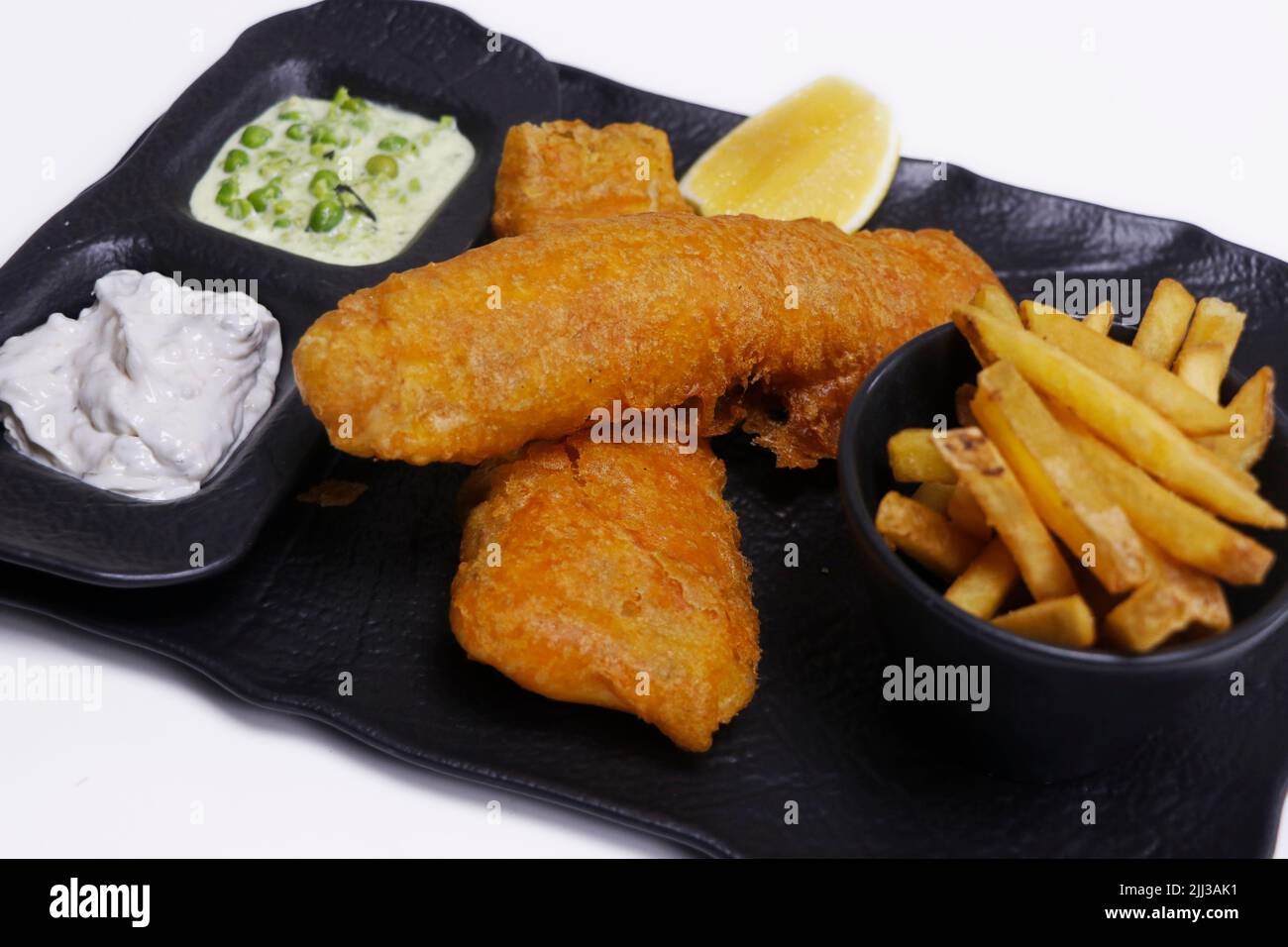 fish and chips plate with battered fried cod fish and french fries with ...