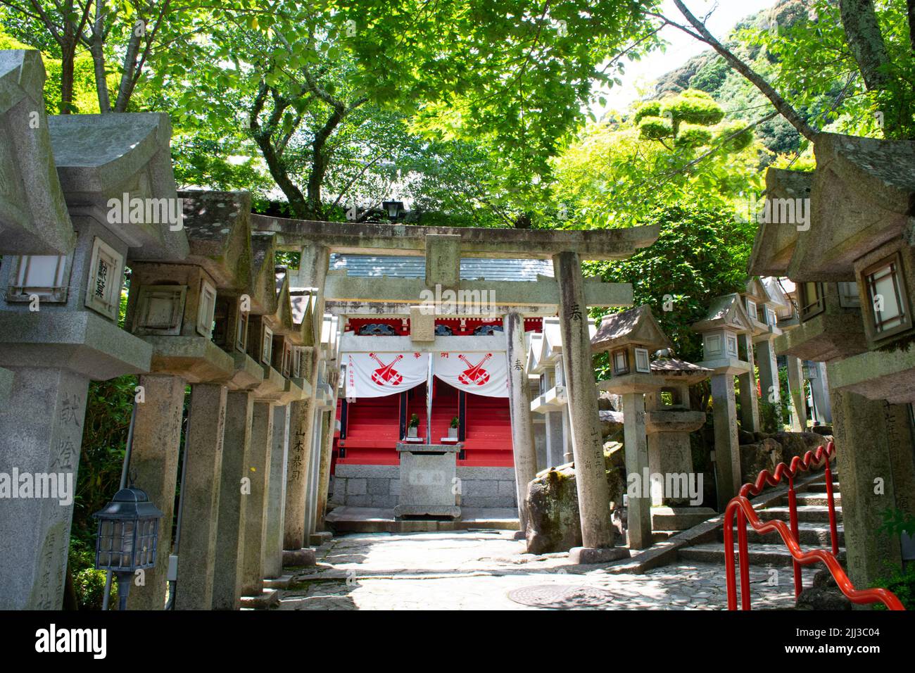 Traditional stone gate to temple - shrine with tree foliage Stock Photo ...