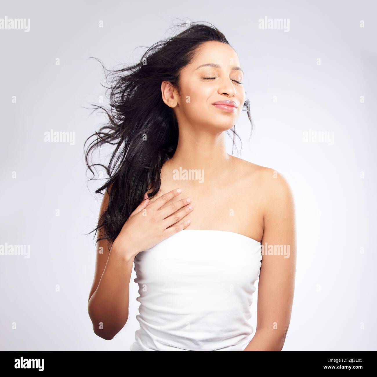 Want your hair to be silky and flowy. a young woman posing against a ...