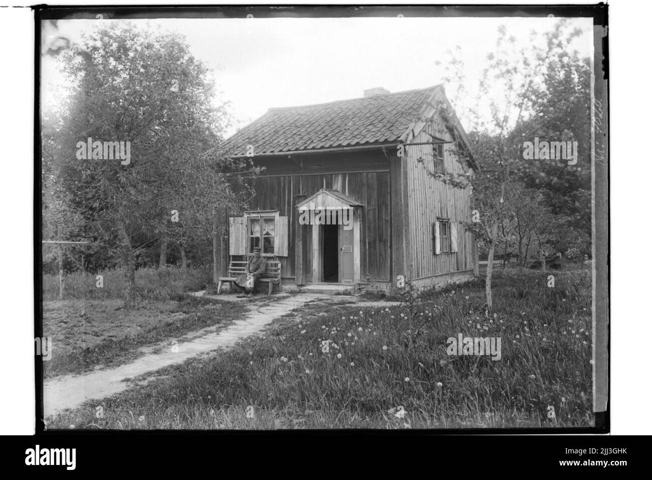 One -story cottage. A man sitting on the couch outside the cottage.100 ...