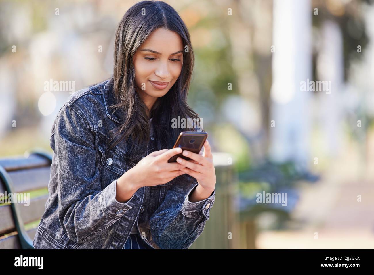 Being away from home is hard. a beautiful young student using her phone ...