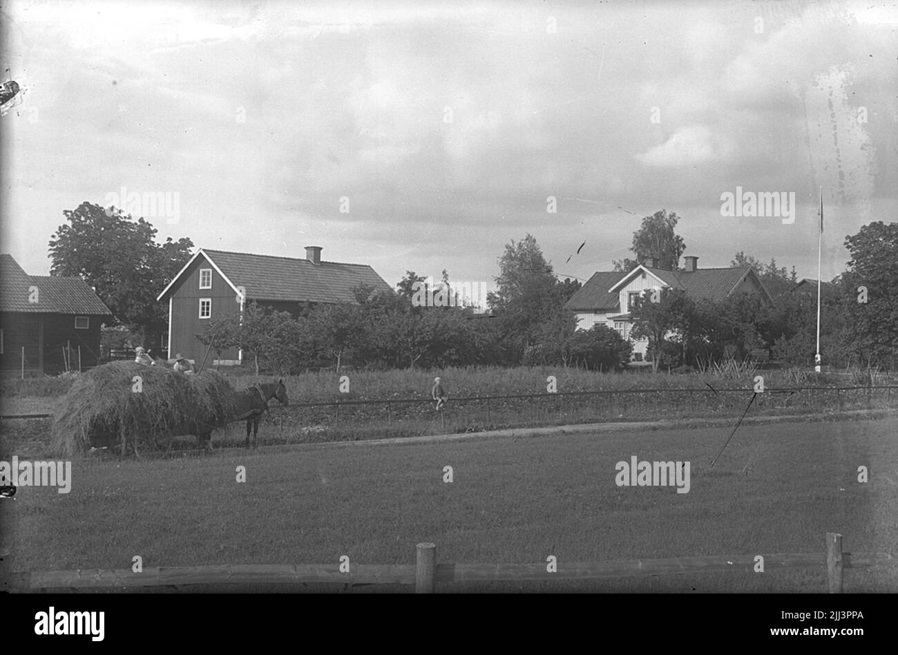 Residential building, horse tense for carriage with hay, two people ...