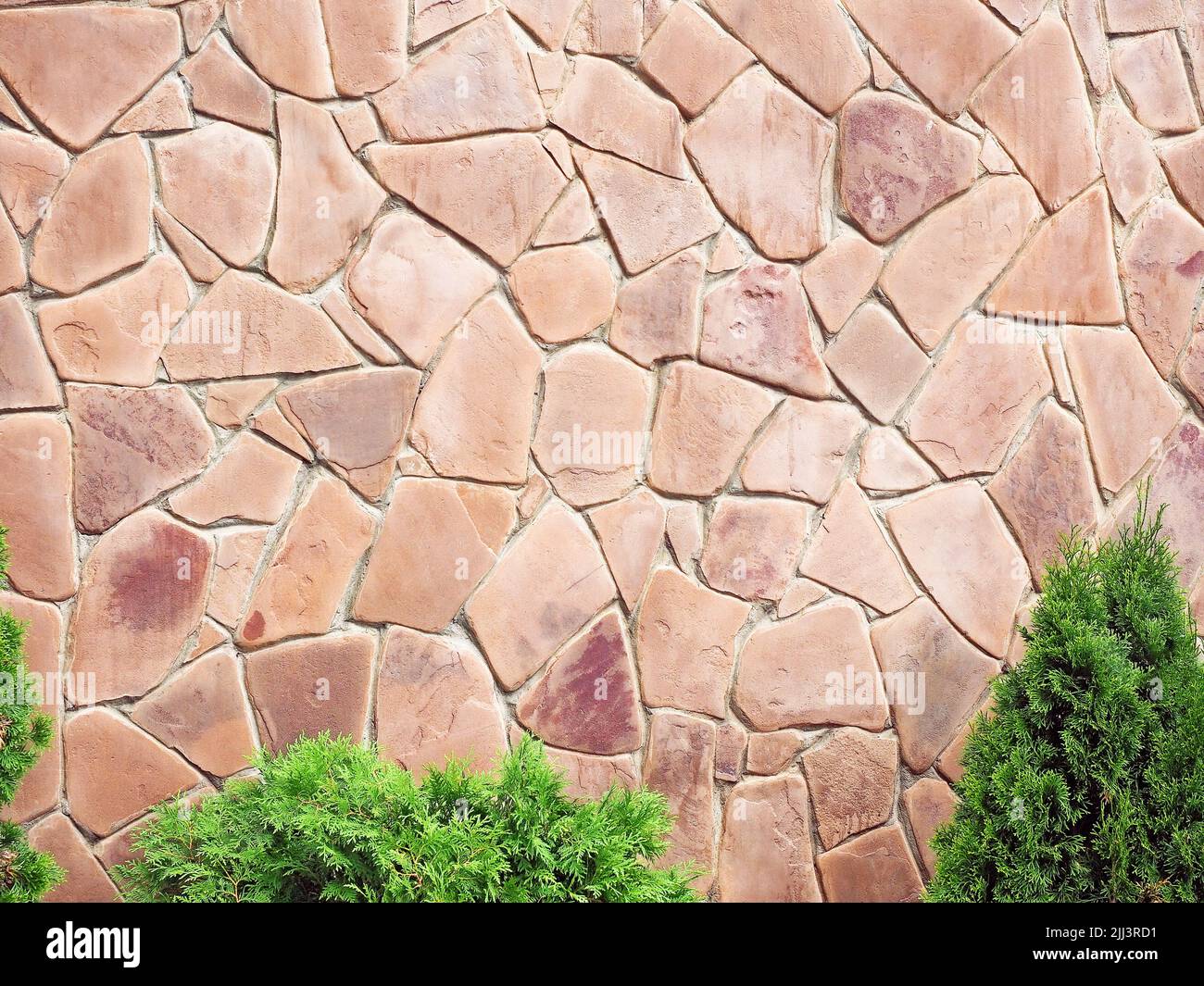 Red sandstone cladding. Exterior wall tiled with granite tiles. Green ...