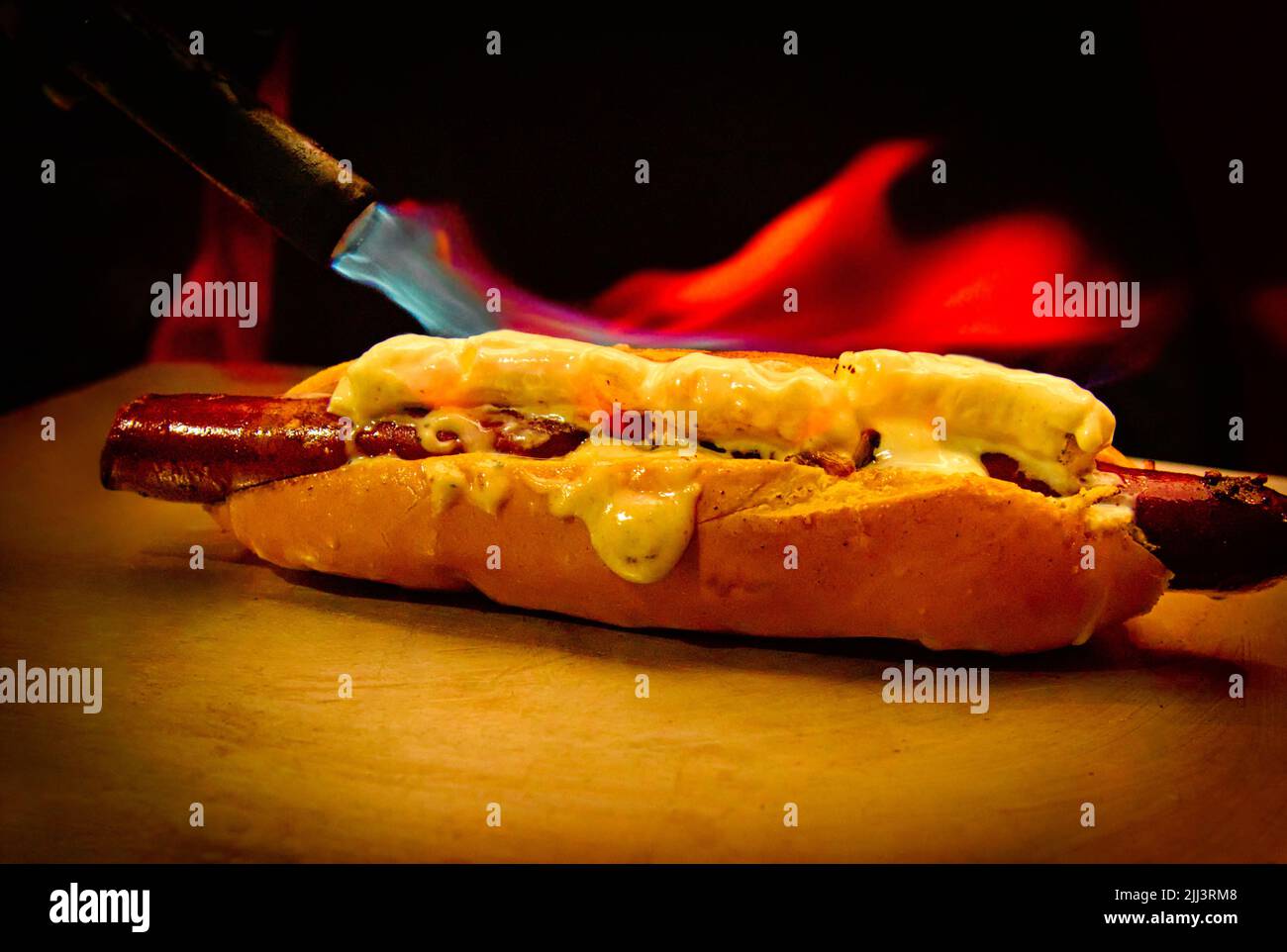 Burger and hot dog cooked on fire during preparation with flamethrower ...