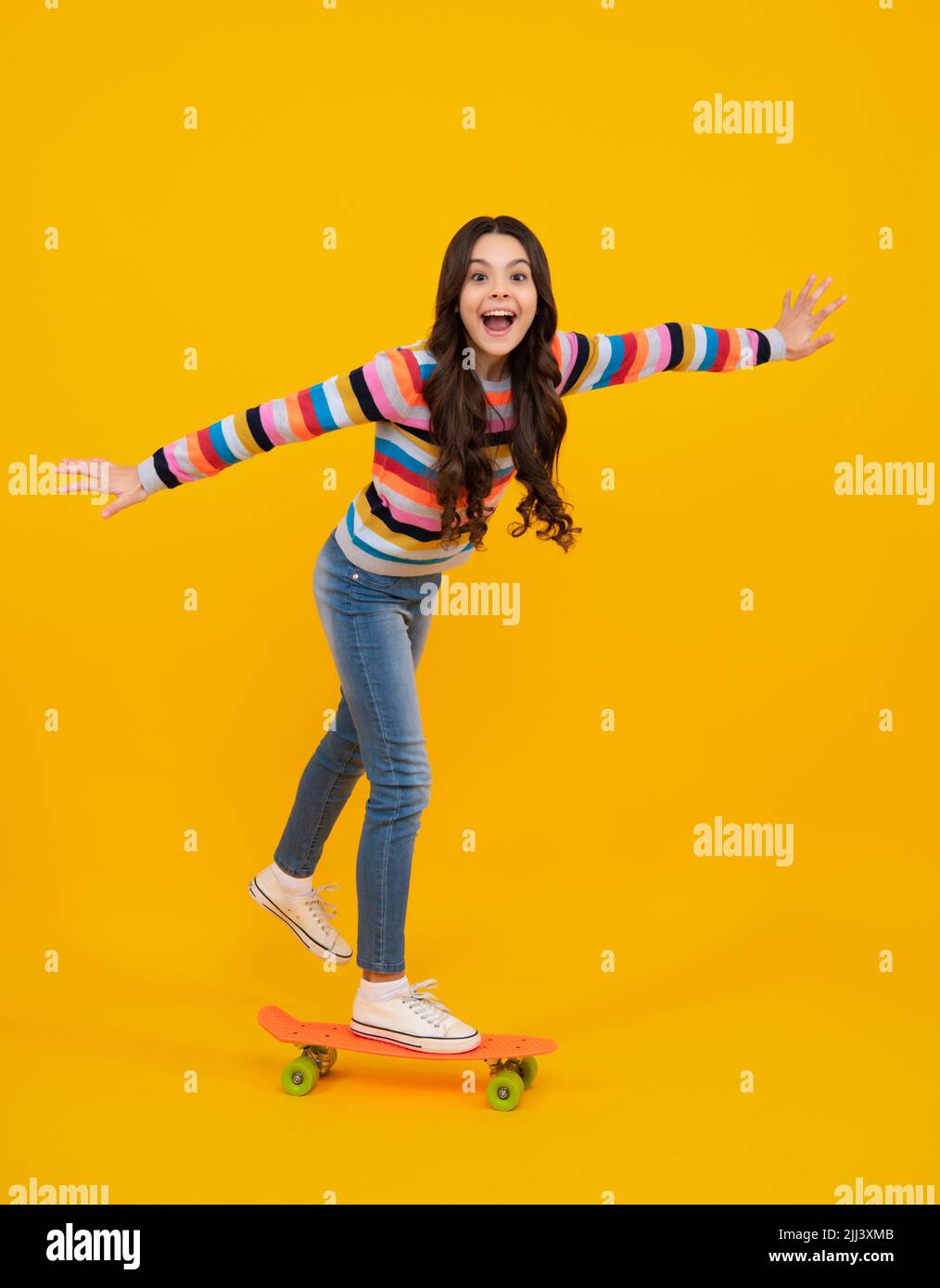 Amazed teenager. Teen girl 12, 13, 14 years old with skateboard over ...