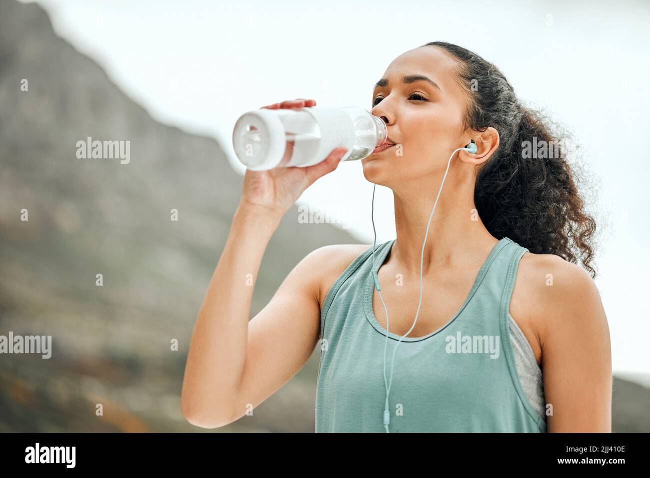 Taking a break to re hydrate. a young woman taking a break from working ...
