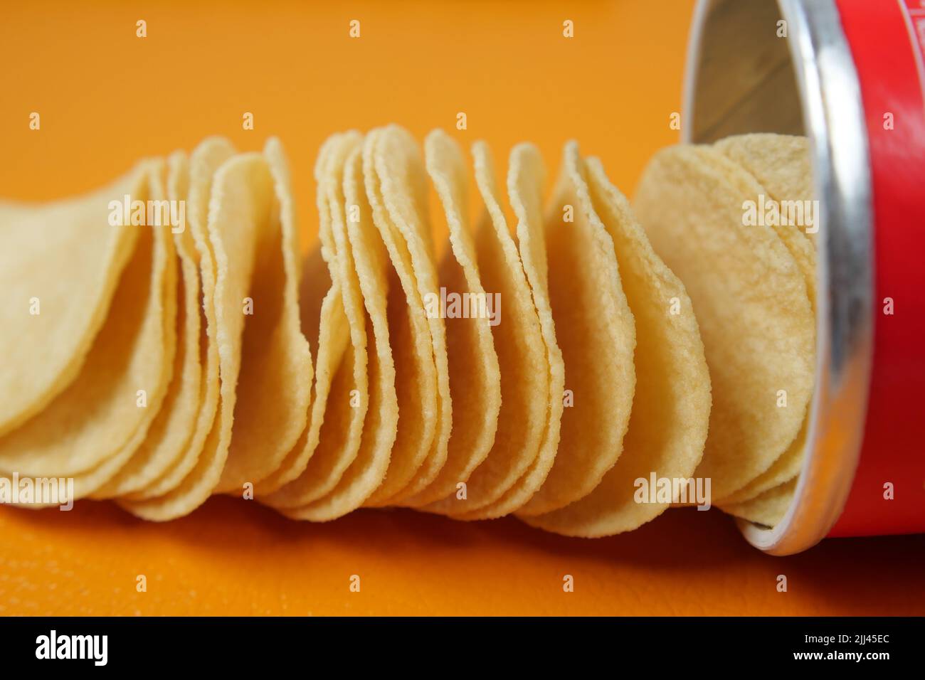 potato chips spilling form a packet on table Stock Photo - Alamy