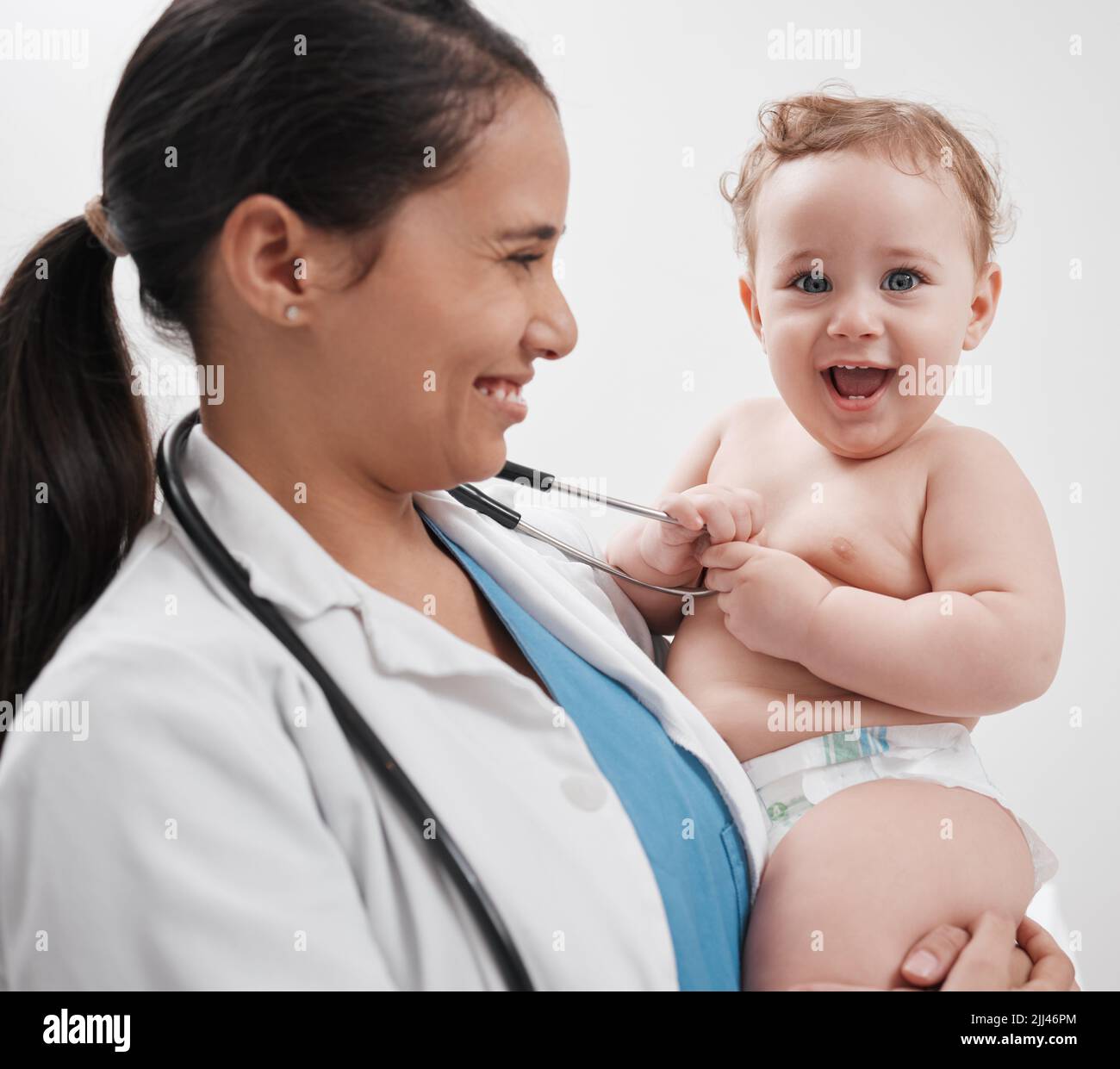 A happy baby is a laughing baby. a paediatrician examining a baby in a ...