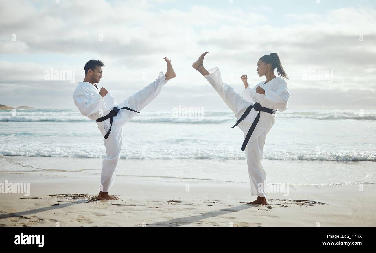 Working on their high kicks. Full length shot of two young martial ...