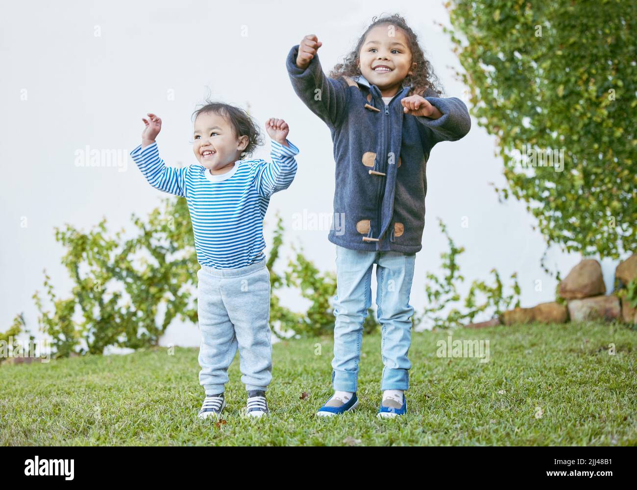 Its playtime. two little girls playing together outside Stock Photo - Alamy
