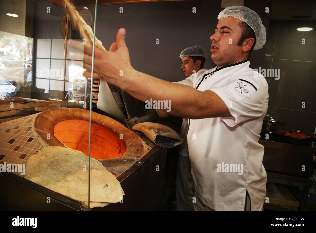ISTANBUL, TURKEY - MAY 14: A baker making Turkish pita bread in tandoor ...