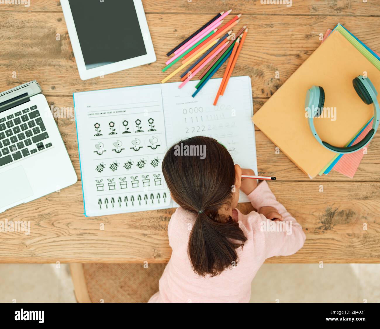 Shes got a lot of homework to do. High angle shot of an unrecognizable ...