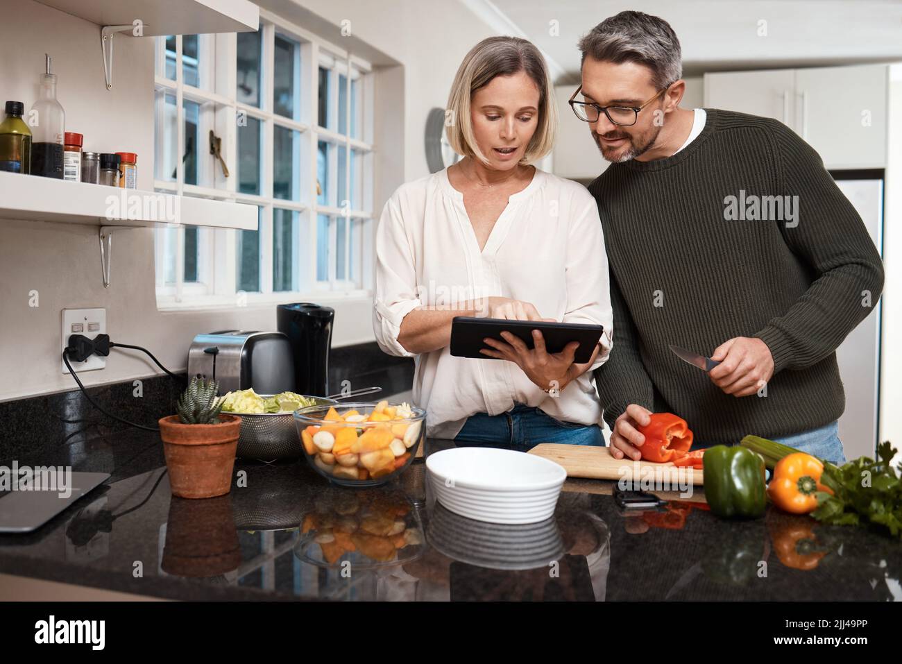 Couple cooking together using a recipe hi-res stock photography and ...