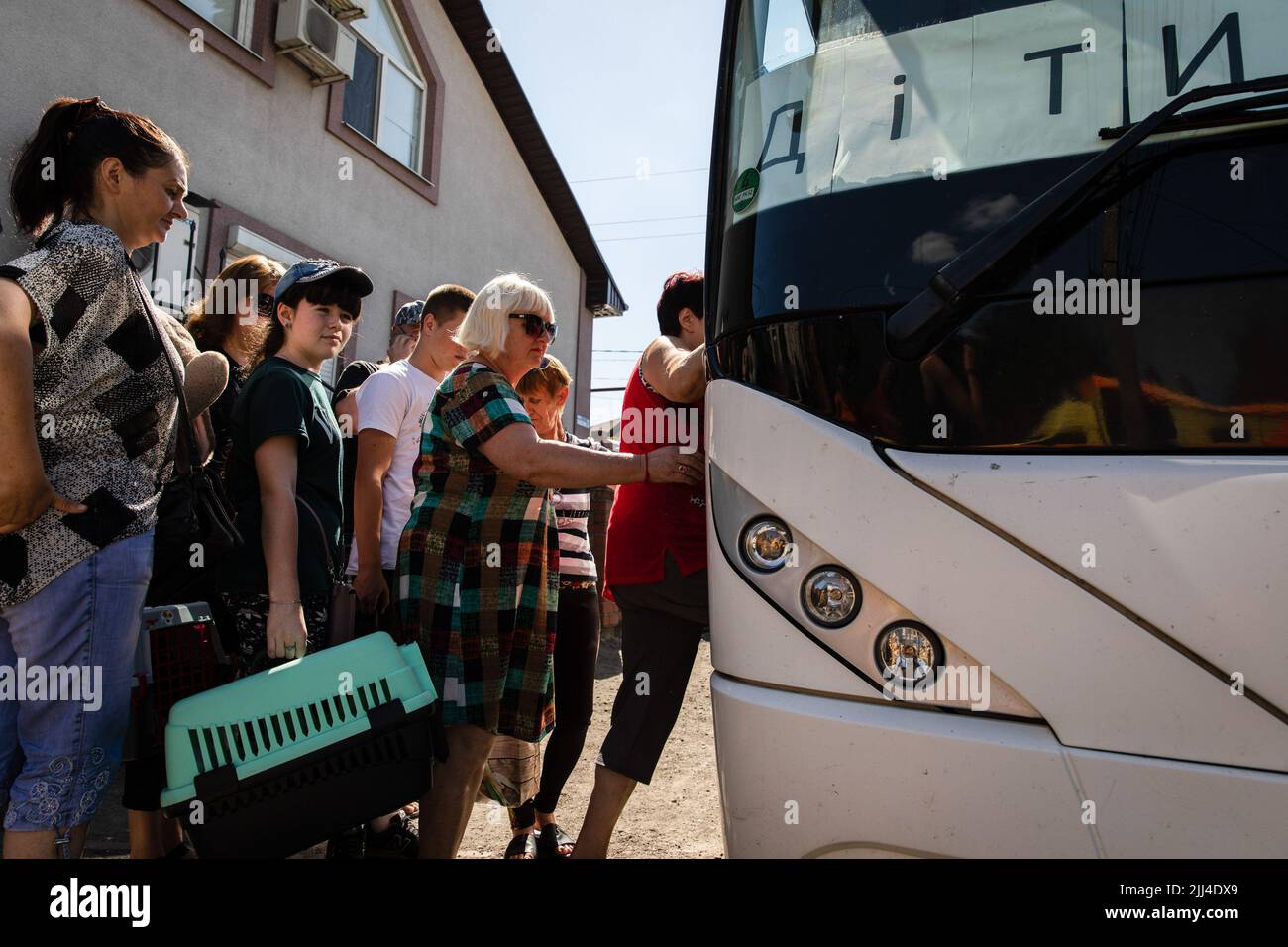 Children and women board a shuttle bus which transports them to the ...