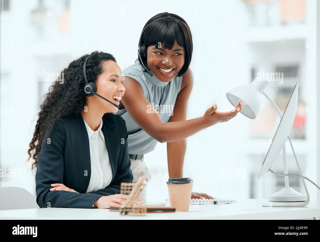 Showing her the ropes. an attractive young female call center agent and ...