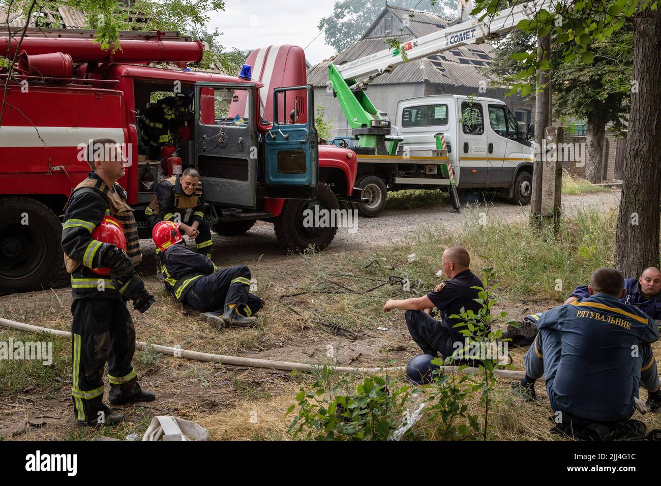 Ukrainian firefighters rest beside their vehicle at the shelling scene ...