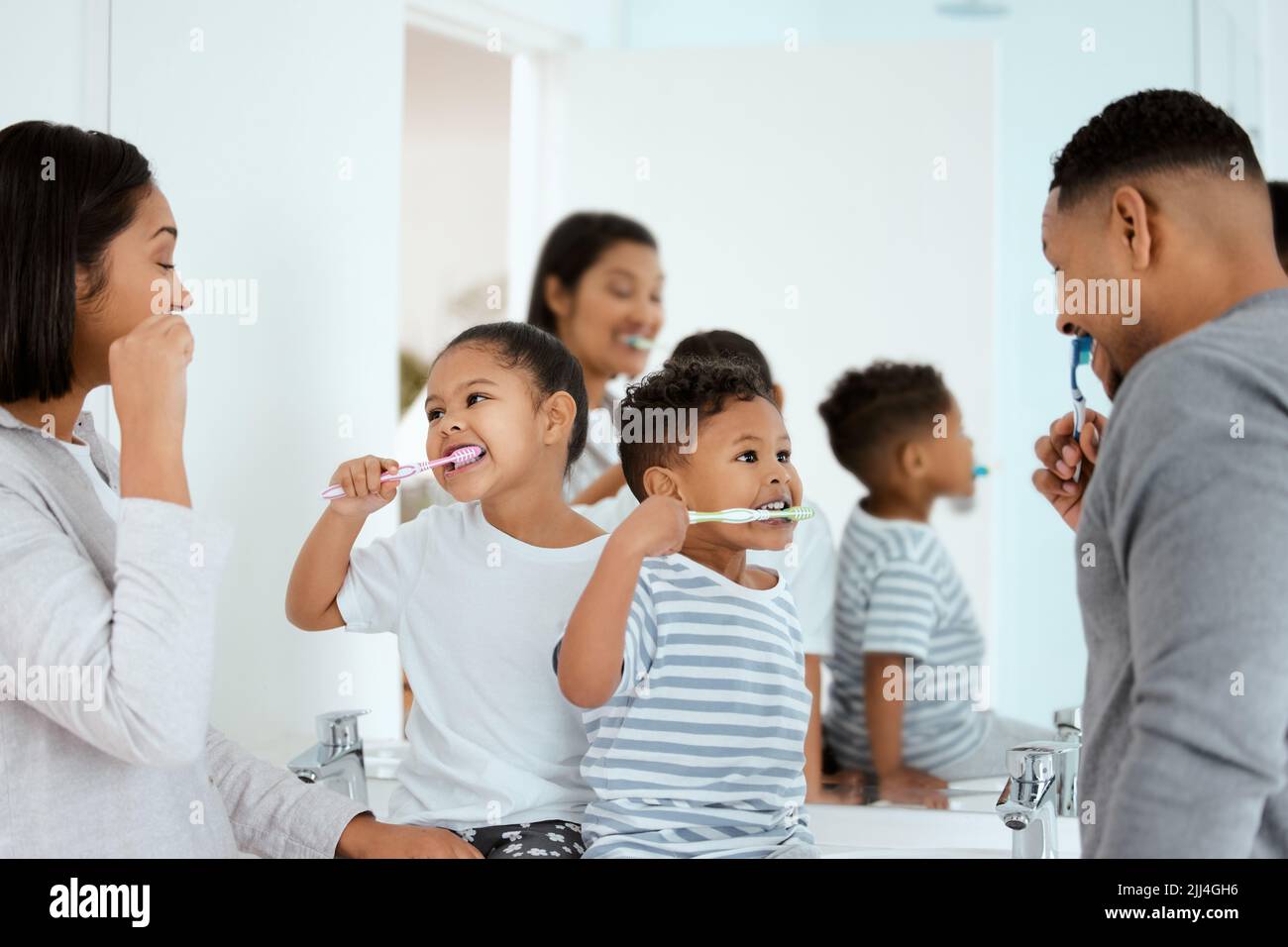 Teaching them by showing them. a beautiful family brushing their teeth ...
