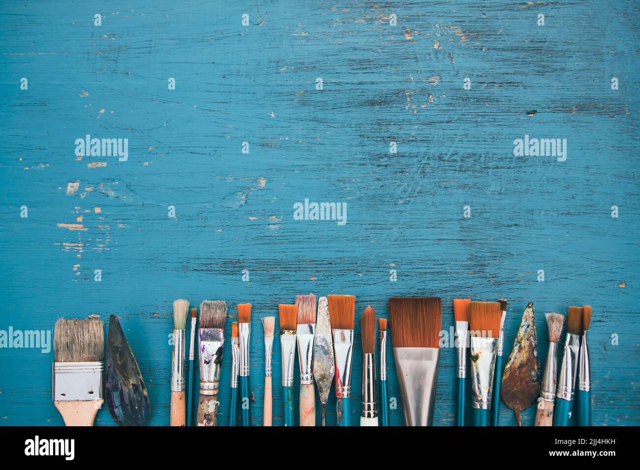 Artistic art supply utensils with paintbrushes on turquoise wooden ...