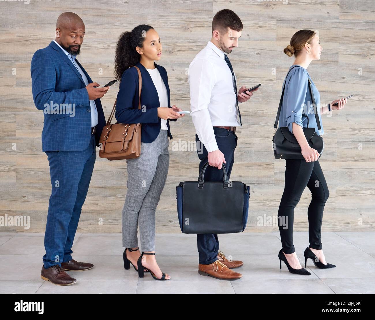 Whos next. a group of businesspeople standing in a line at an office ...