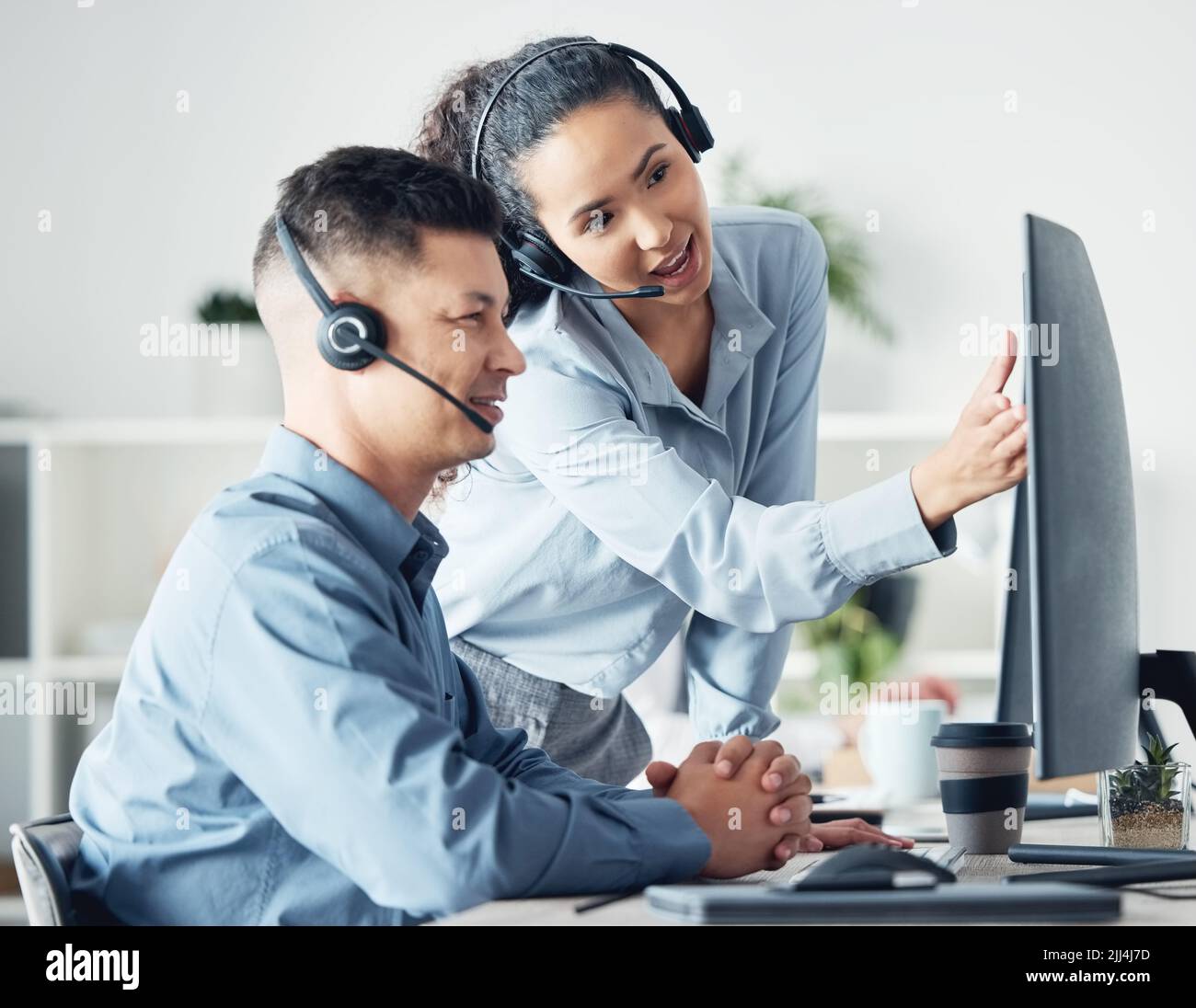 Collecting and analysing customer feedback. two call centre agents working together on a ...