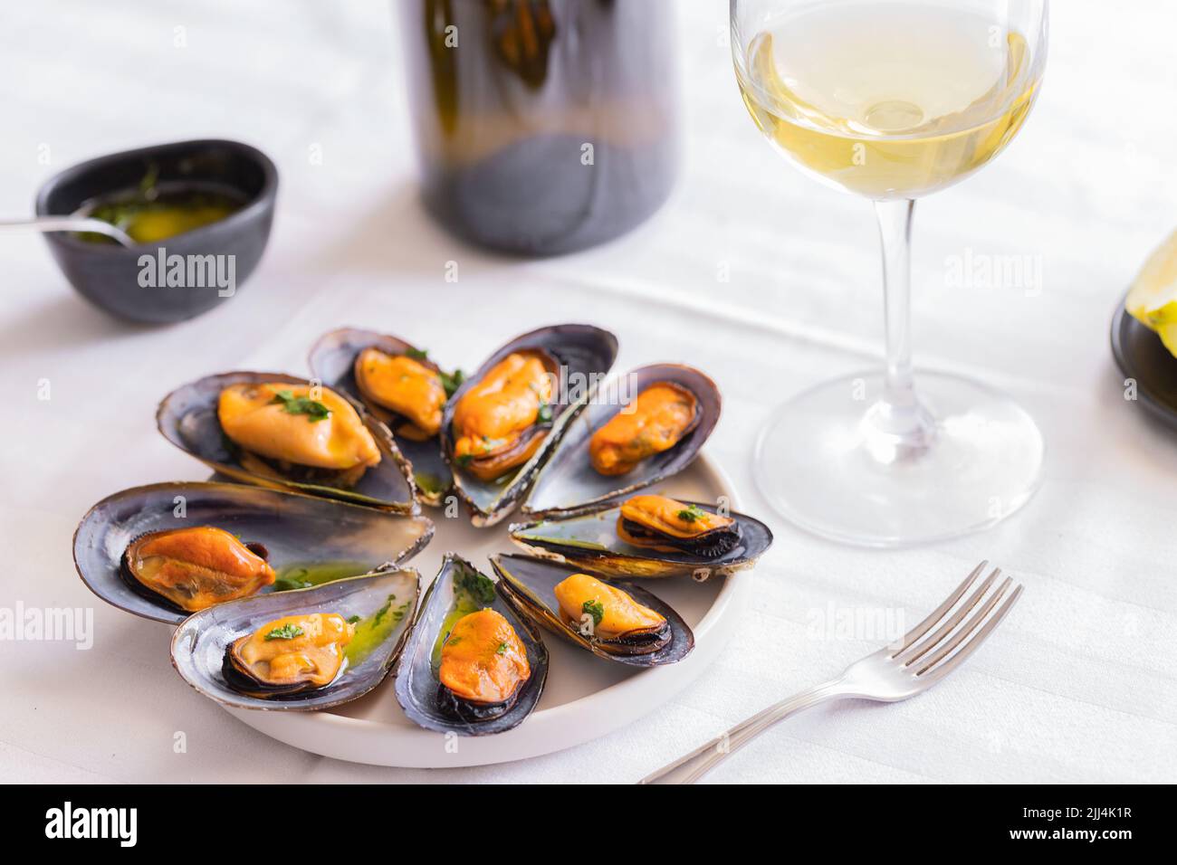 Steamed black mussels cooking in sauce and served with wine. Popular ...