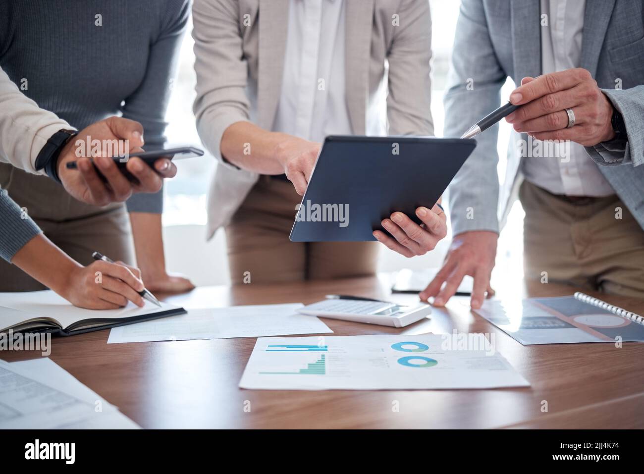 Delving into the details. a group of unrecognizable businesspeople ...