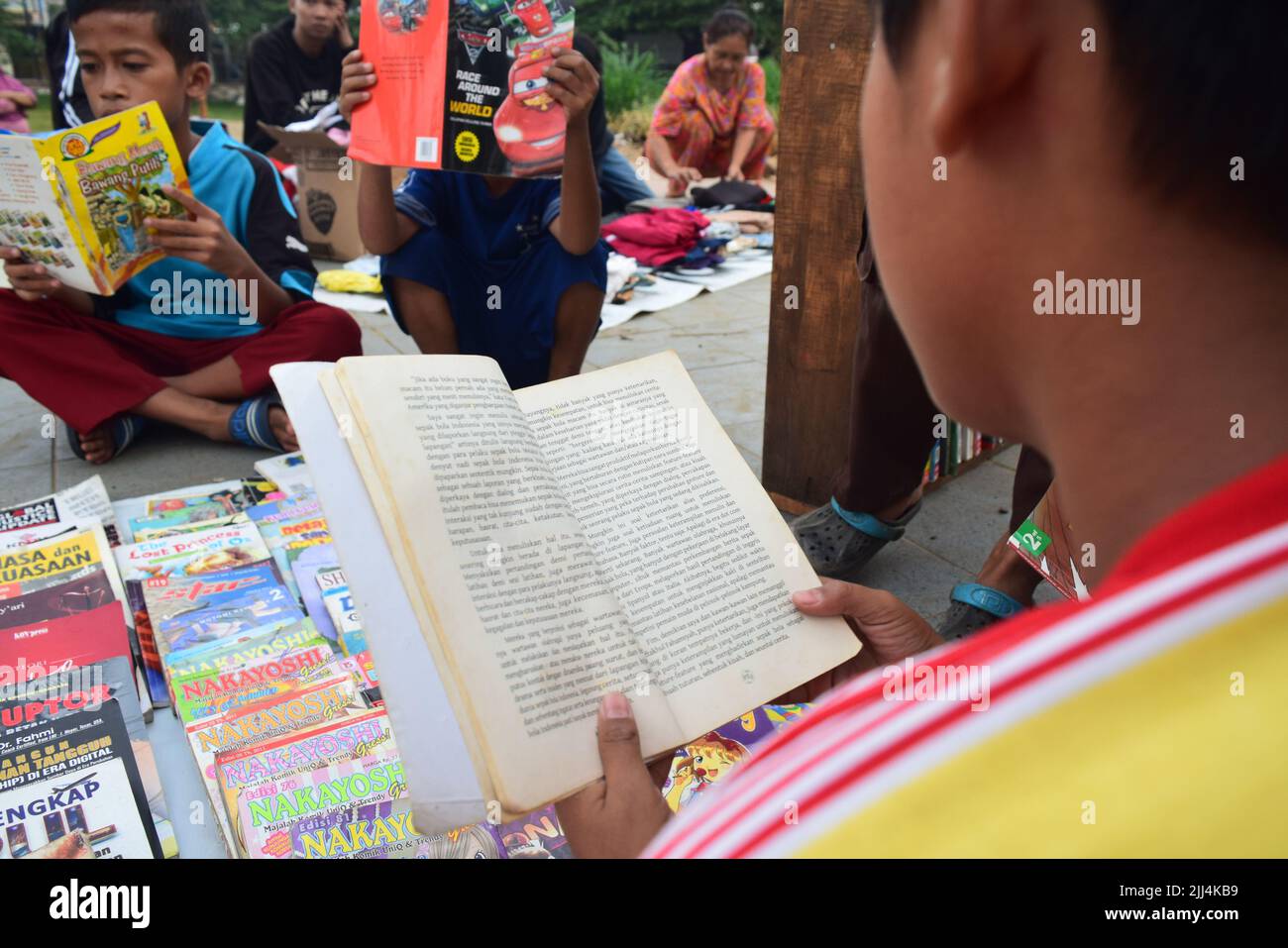 Indonesia, 2021 : children reading a book in a public space park at ...