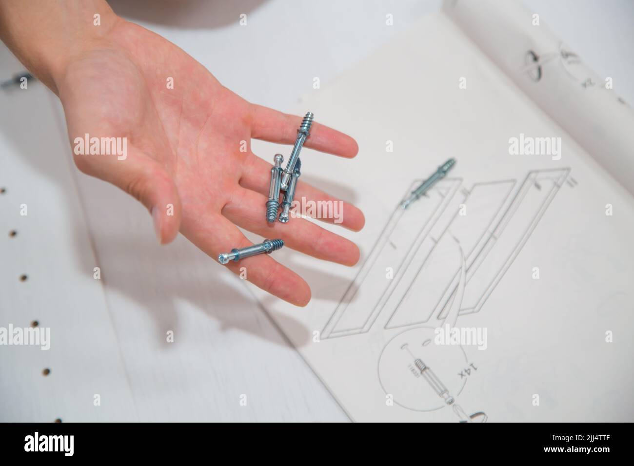 Screws in hand of man on the drawings background Stock Photo - Alamy
