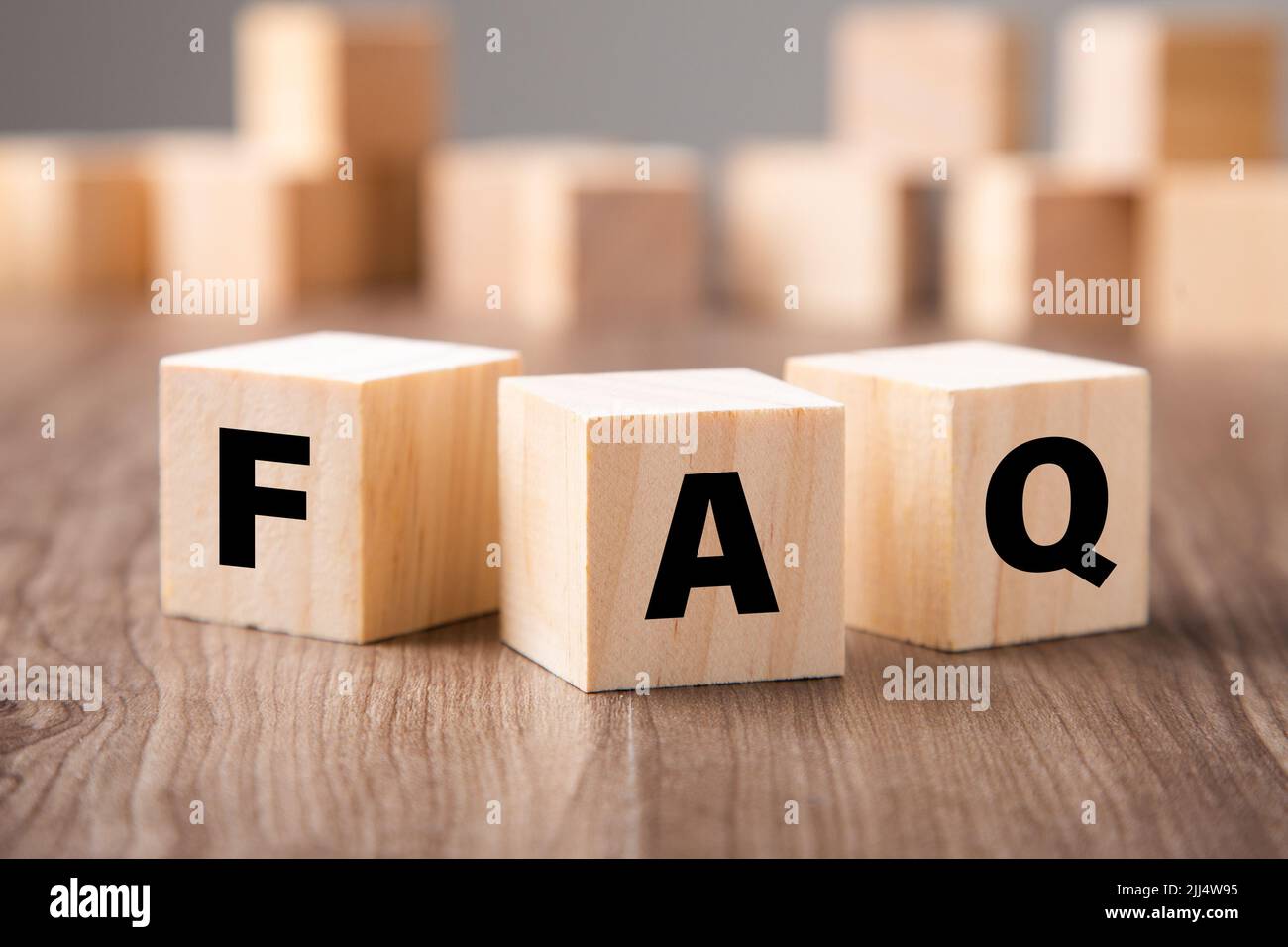 Wooden blocks with word FAQ on wooden background. Frequently asked ...