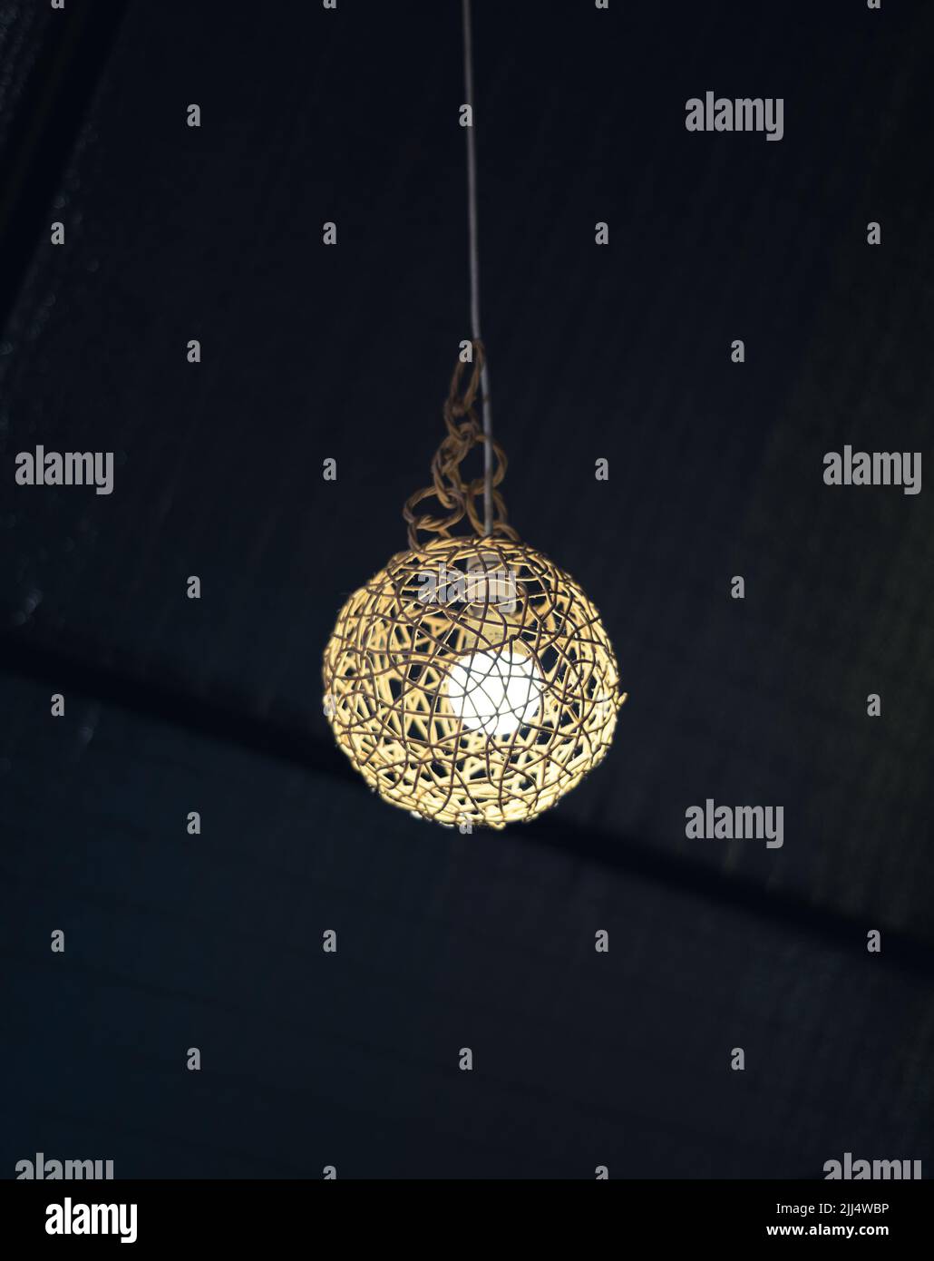 A glowing round light bulb against the dark ceiling Stock Photo - Alamy
