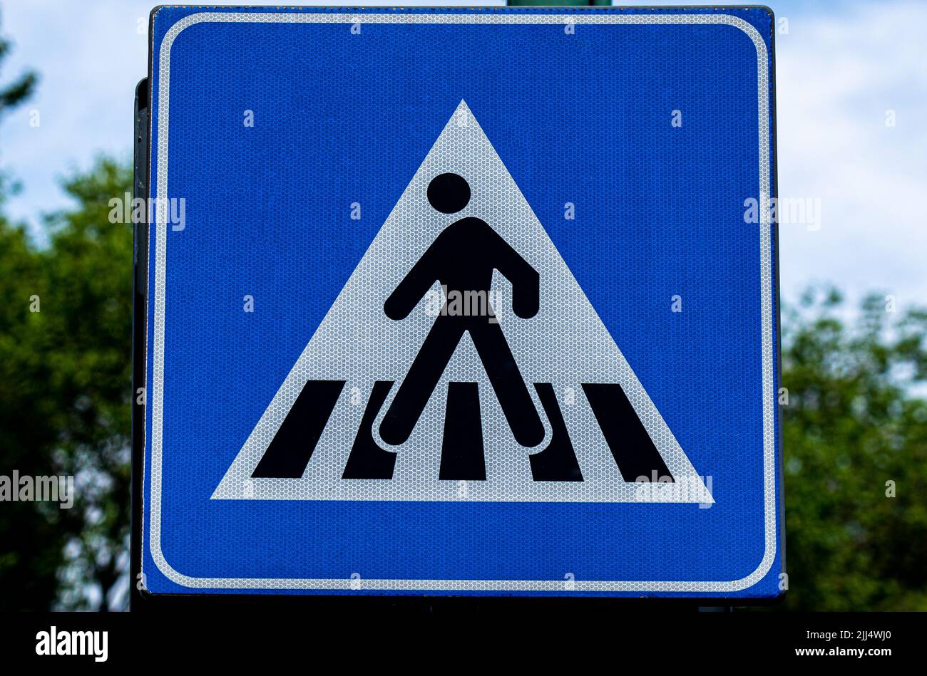 Color road sign in the foreground indicating the presence of a ...