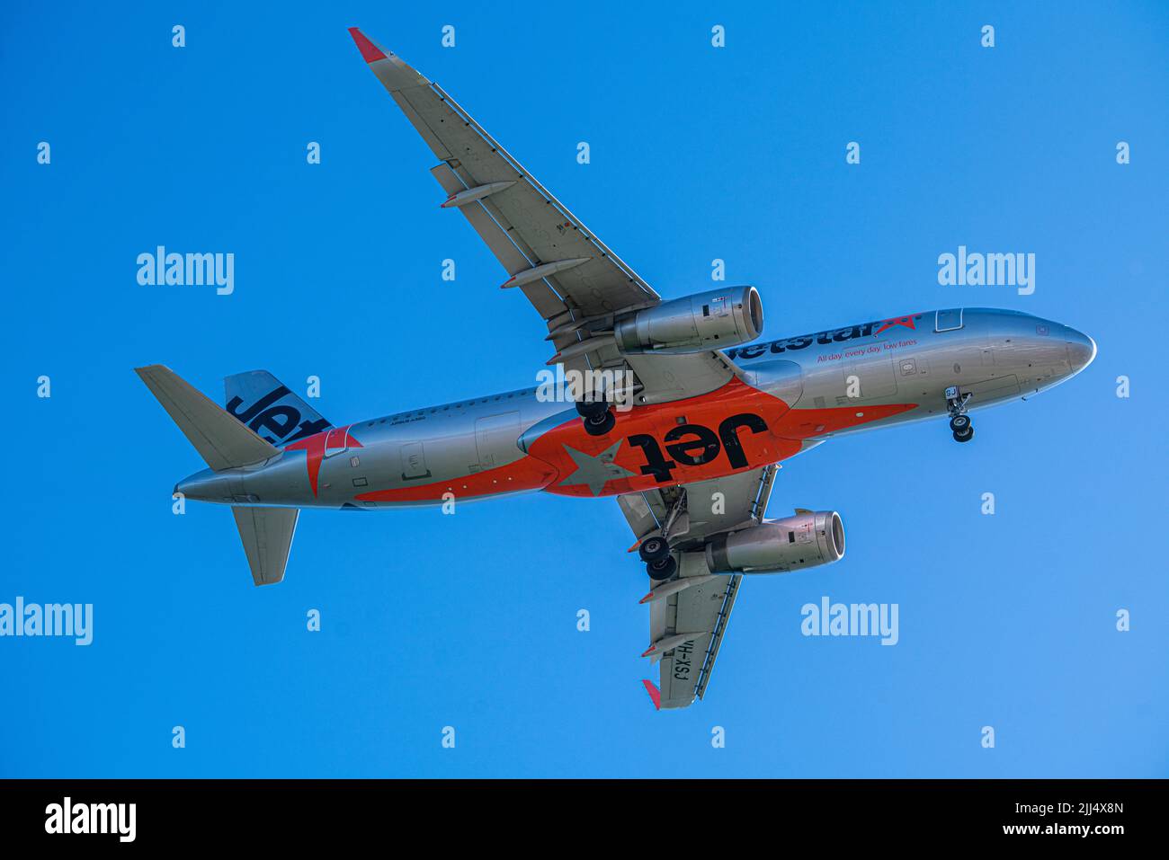 23 July 2022: The underside of a Jetstar commercial jet on approach to ...
