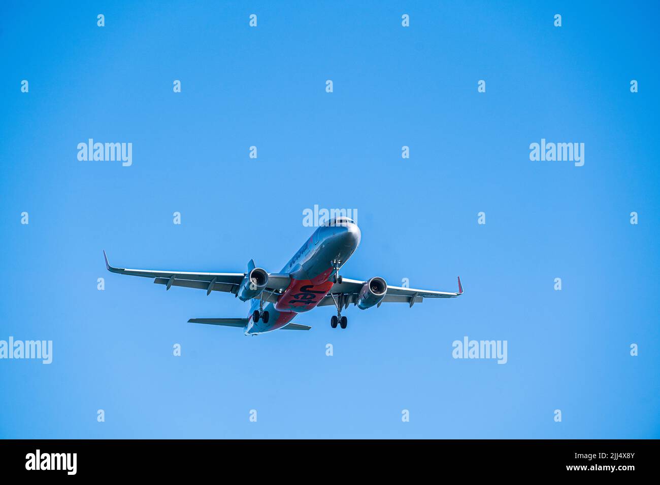 23 July 2022: The underside of a Jetstar commercial jet on approach to ...
